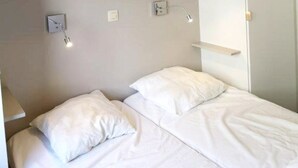 Quarto com uma cama, duas mesas de cabeceira e um guarda-roupa.