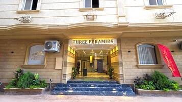 Um edifício com uma placa que diz 'Three Pyramids' e uma bandeira vermelha.