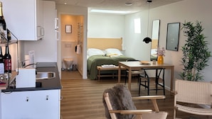 Apartamento moderno com cozinha, sala de jantar e um quarto.