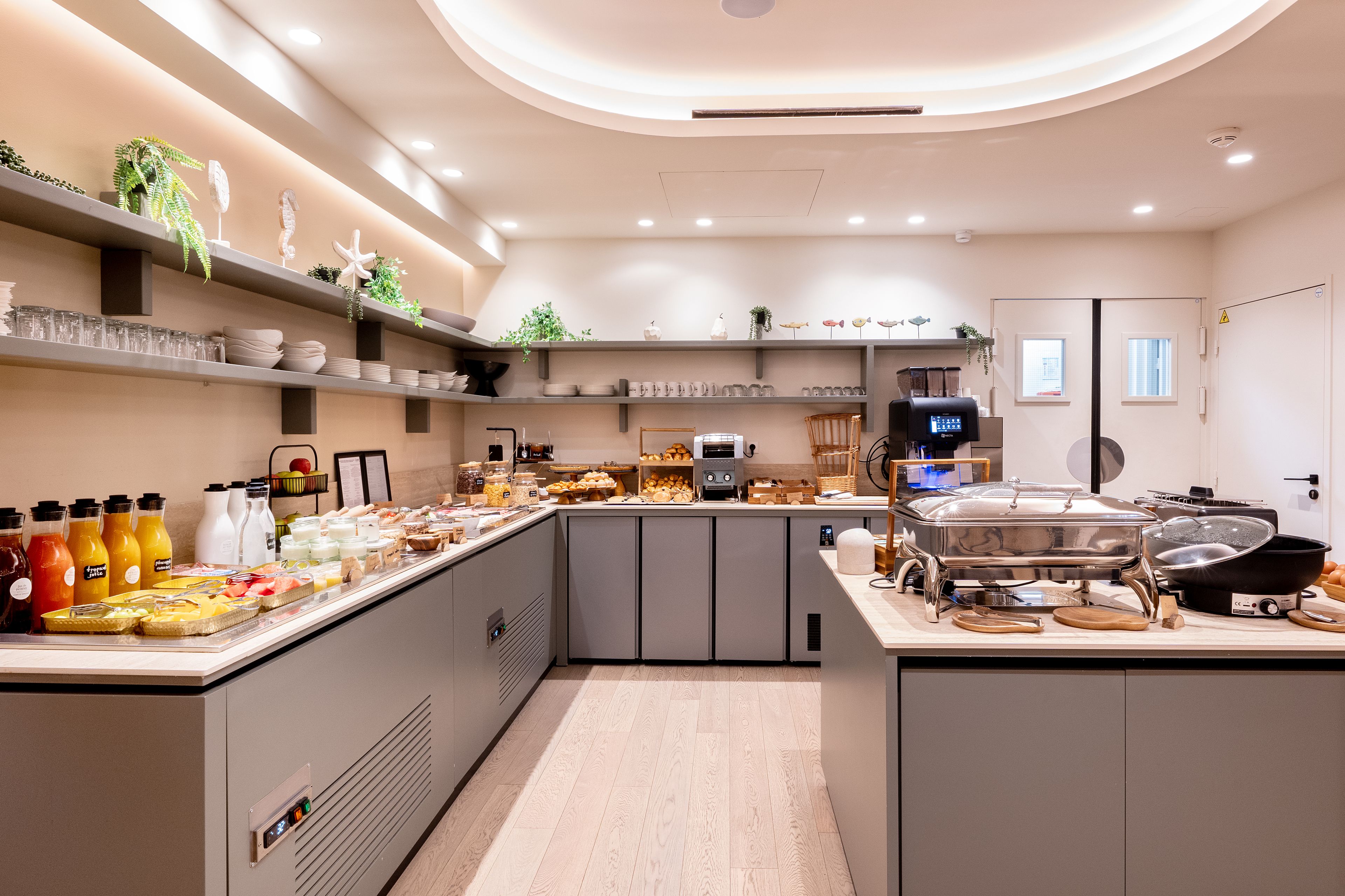 Cozinha moderna com ilha central, equipada com diversos eletrodomésticos e um serviço de buffet.