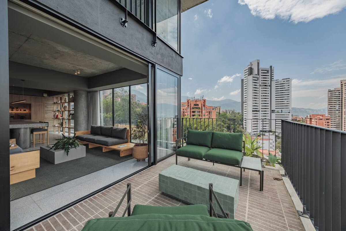 Um apartamento moderno com varanda, janelas amplas e cozinha.