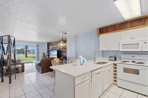 Condo com design assinado, 2 quartos, para não fumantes, de frente para a praia | Cozinha privada | Geladeira, micro-ondas, fogão, cooktop