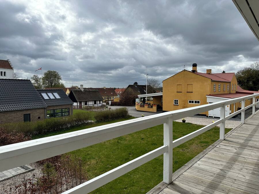 Um bairro residencial com casas, um deck de madeira e um gramado.
