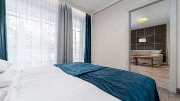 Quarto de hotel com cama, escrivaninha, cadeira e espelho.