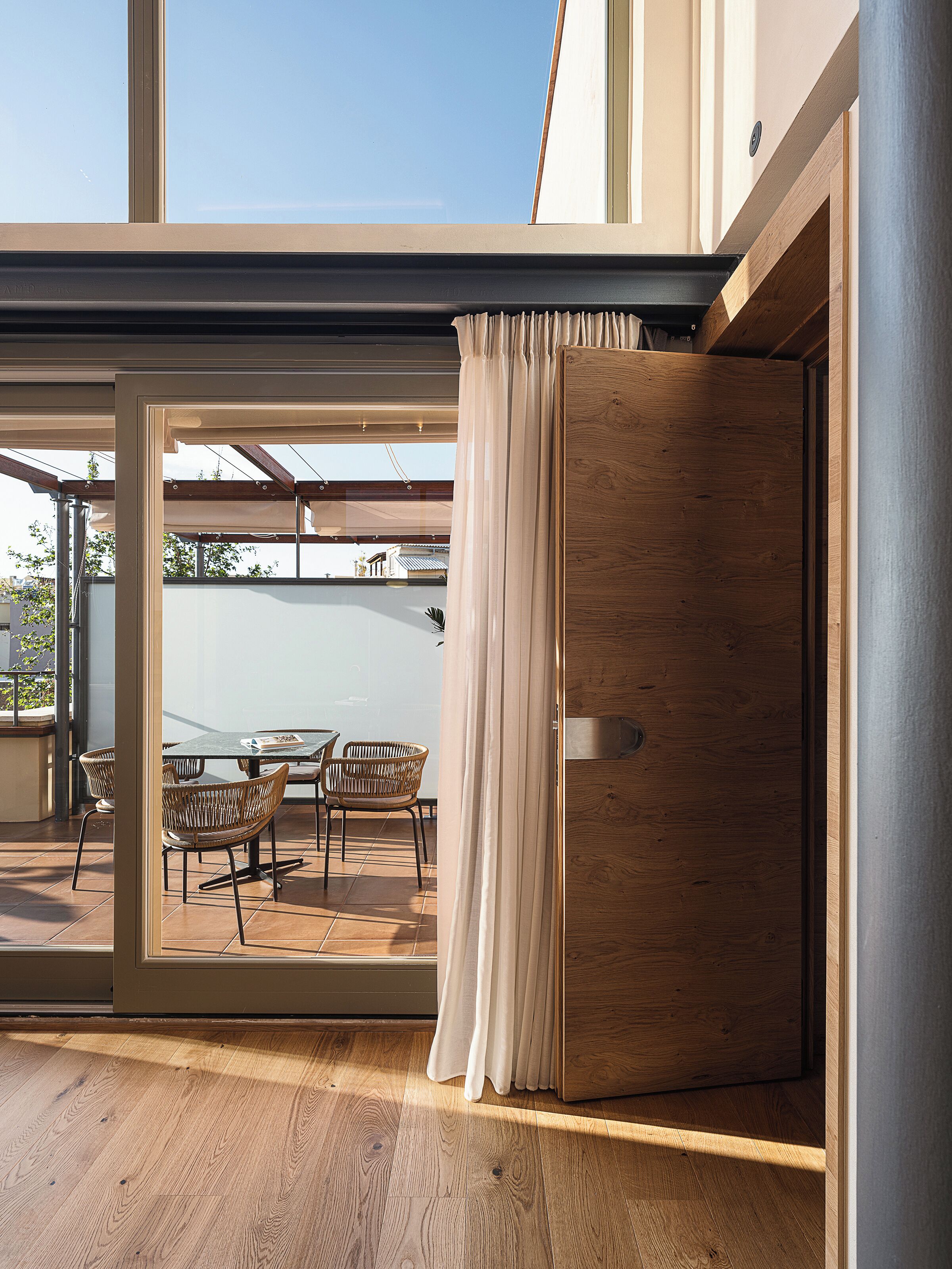 Quarto moderno com uma grande porta de vidro deslizante que dá para uma área de varanda externa.