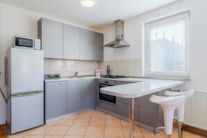 Um frigorífico, um forno, uma placa de cozinha, uma chaleira elétrica