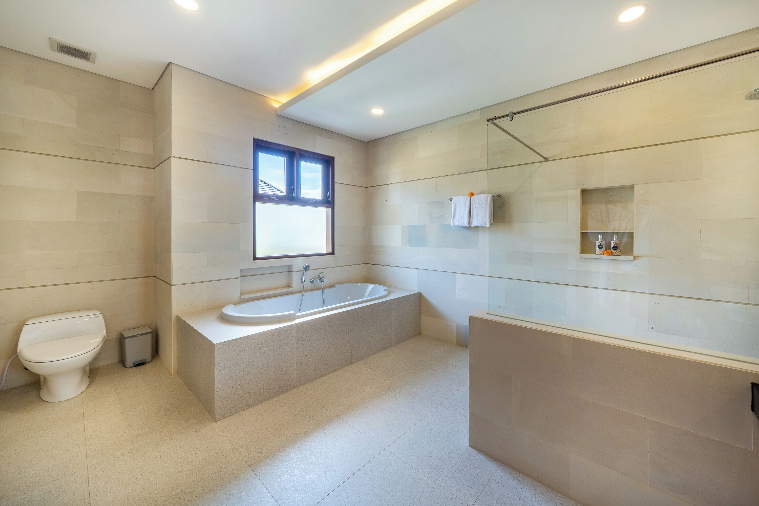 Uma casa de banho moderna com sanita, banheira e lavatório.