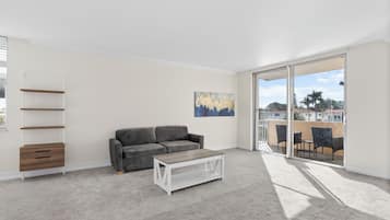 Apartamento, sacada, vista para a baía | Sala de estar | TV de tela plana