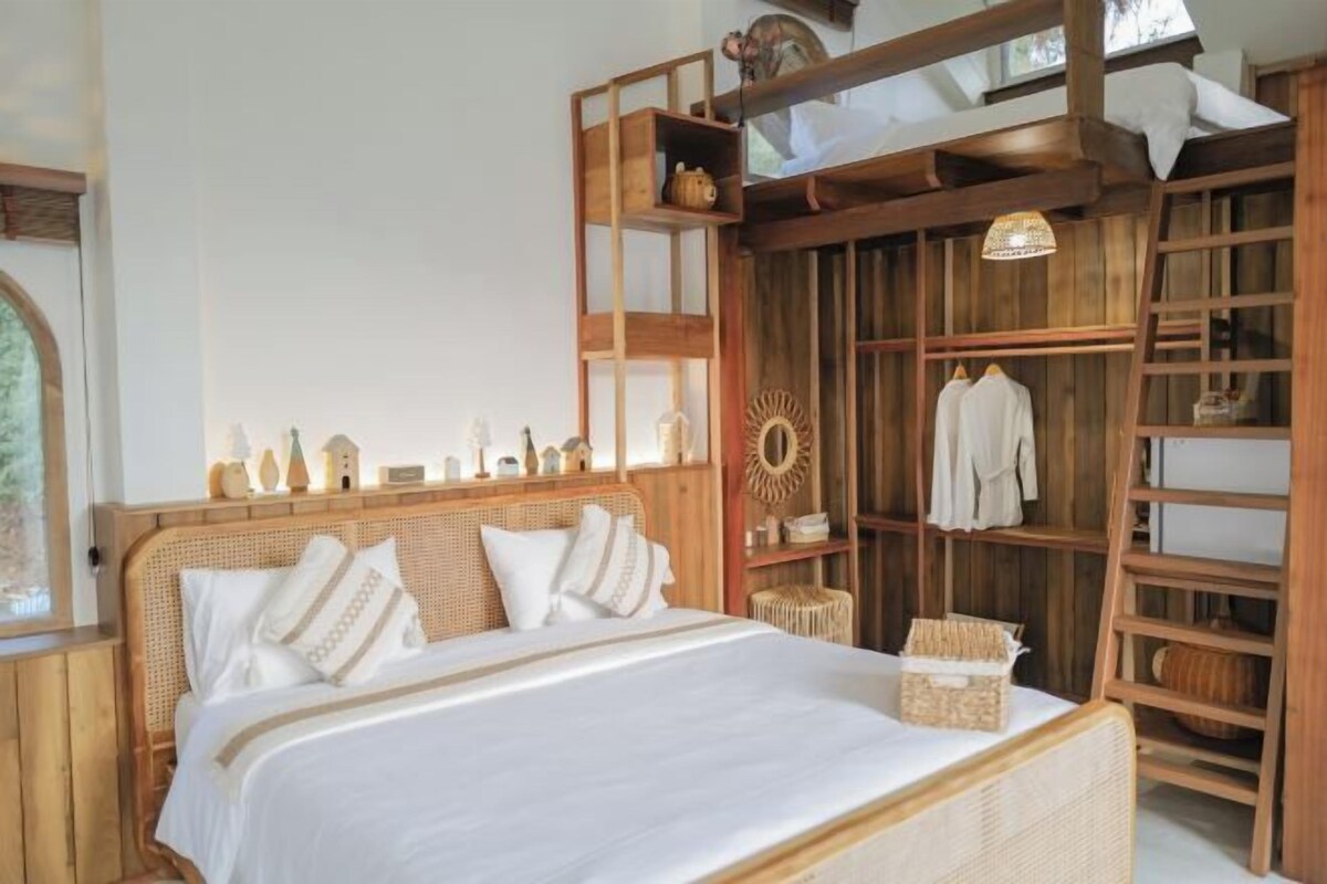 Quarto com cama grande, cabeceira de madeira e guarda-roupa embutido com prateleiras e espaço para pendurar.