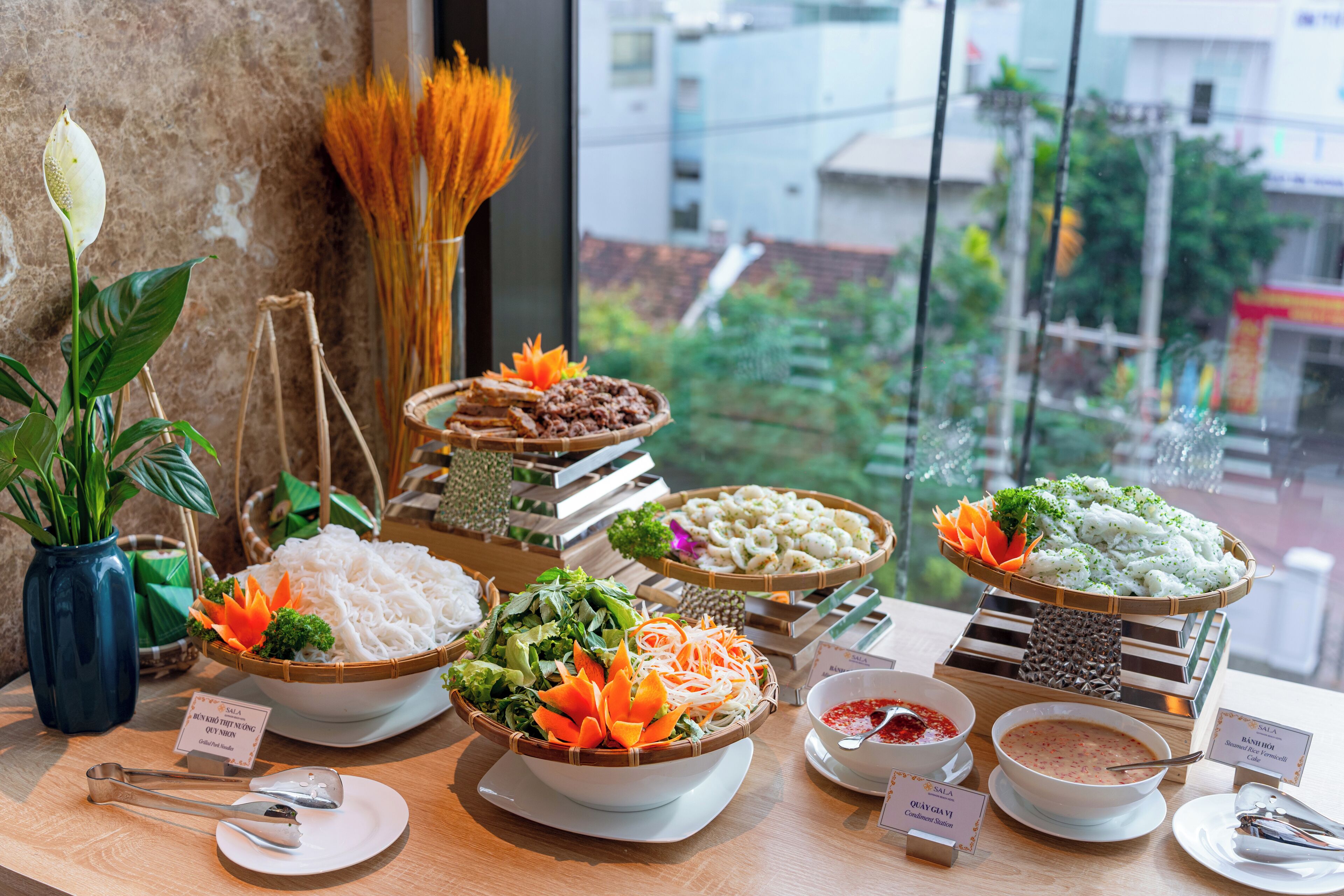 Uma mesa de buffet com diversos pratos, incluindo macarrão, legumes e arroz.