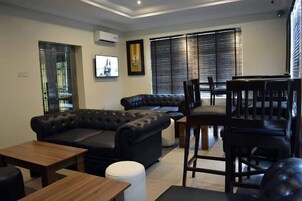Uma sala de estar moderna com um sofá modular, uma mesa de jantar e um espaço de bar.