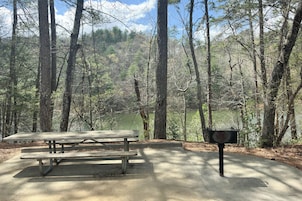 Uma mesa para piquenique em área arborizada com uma caixa de correio.