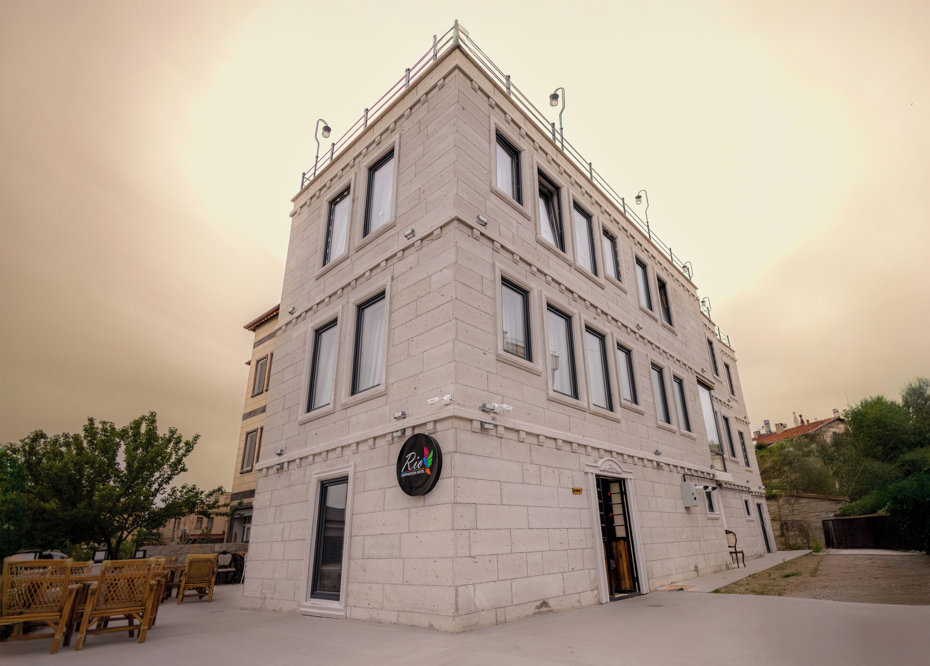 Um edifício de vários andares com entrada na esquina, janelas amplas e uma placa indicando um restaurante.