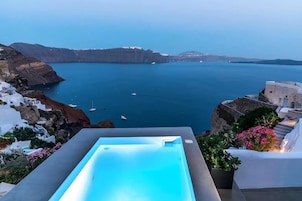 Piscina com vista para o mar e um penhasco.