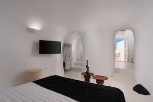 Quarto moderno com cama, televisão de tela plana, luminária e vista para uma varanda.