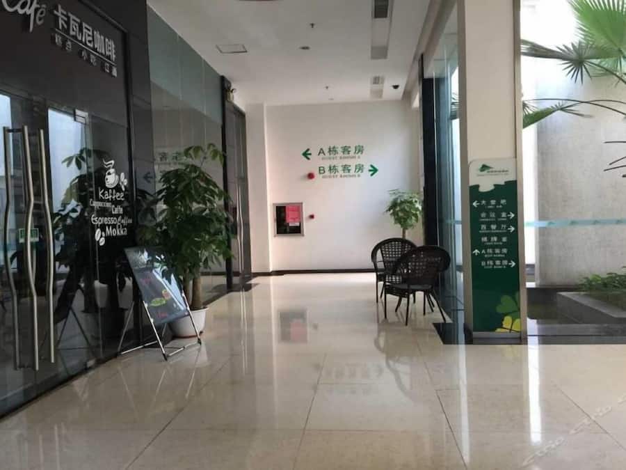 Corredor de hotel com placas de sinalização indicando os quartos e as comodidades.