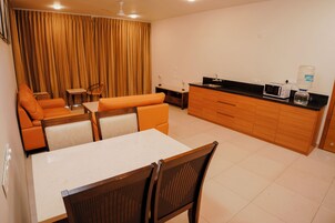 Um espaço compacto com área de refeições, cozinha compacta e espaço de estar com cortinas.