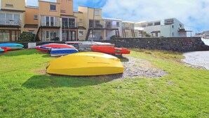Um complexo de edifícios à beira-mar, com várias varandas e um gramado frontal.
