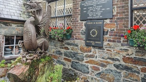 Um edifício de pedra com uma placa que lista prêmios ambientais e uma escultura decorativa de dragão.