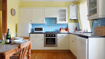 Um frigorífico, uma máquina de lavar louça, utensílios de cozinha
