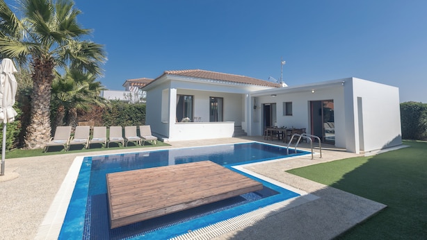 Uma casa moderna com piscina, deck de madeira e área de varanda.