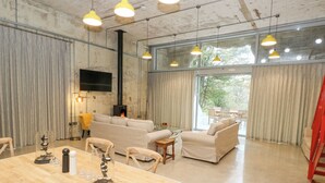 Uma sala de estar espaçosa, com um sofá grande, uma mesa de jantar com cadeiras e uma lareira.
