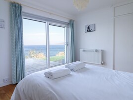Quarto com cama, vista para o mar e radiador.