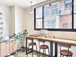 Cozinha moderna com uma janela grande, banquetas e uma planta.