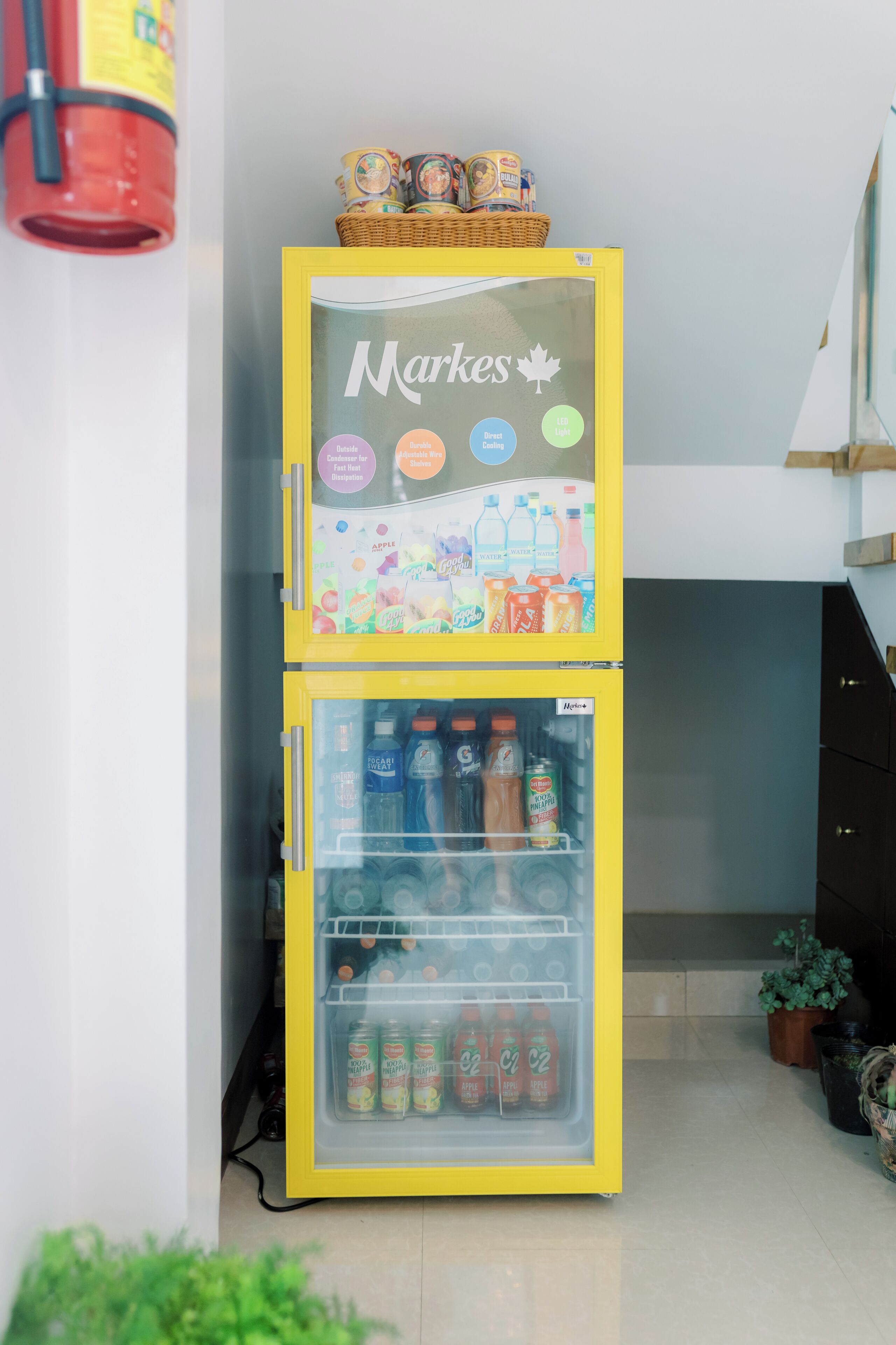 Máquina automática amarela com porta de vidro, contendo diversas bebidas e lanches.