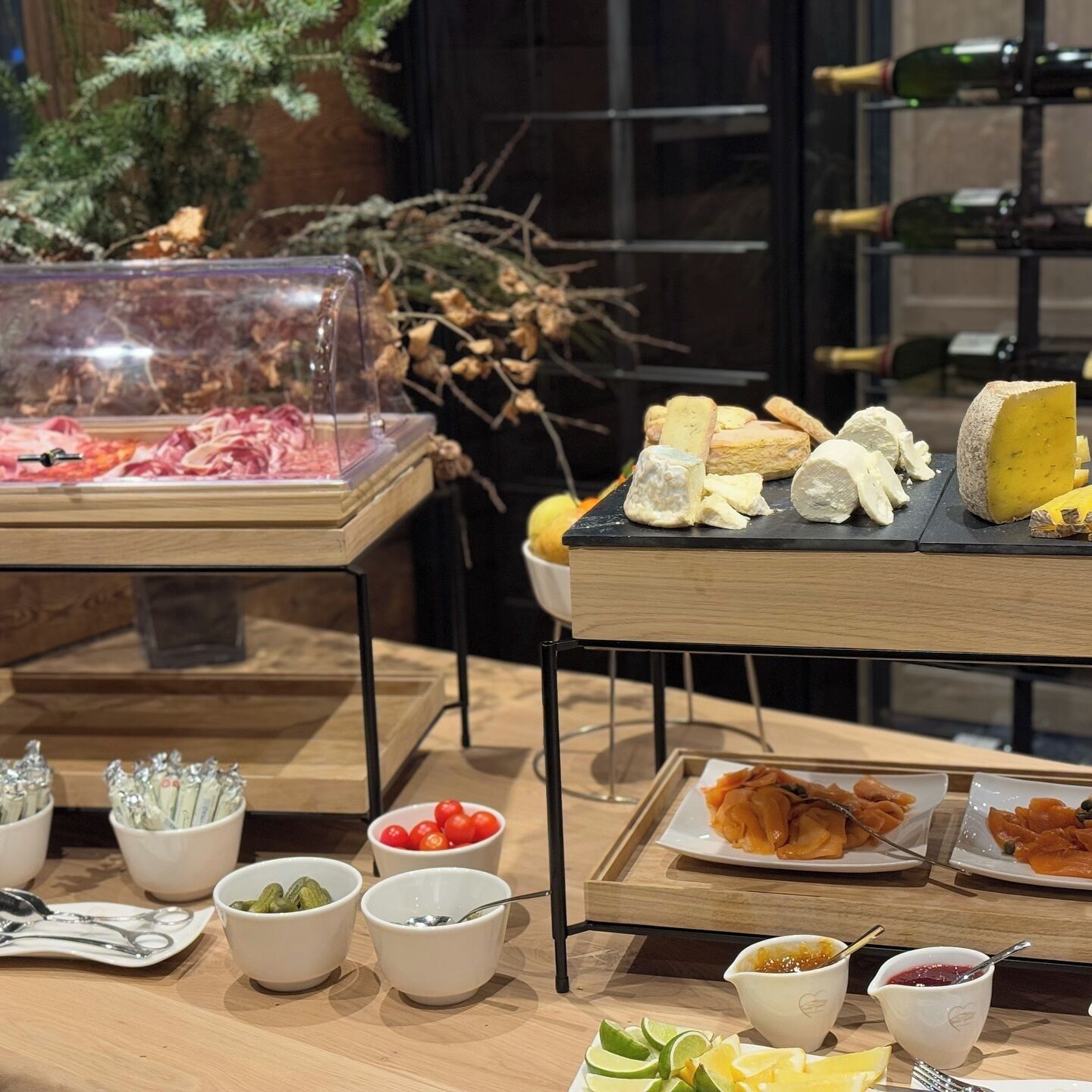 Buffet com diversos alimentos, incluindo queijos, carnes e frutas.