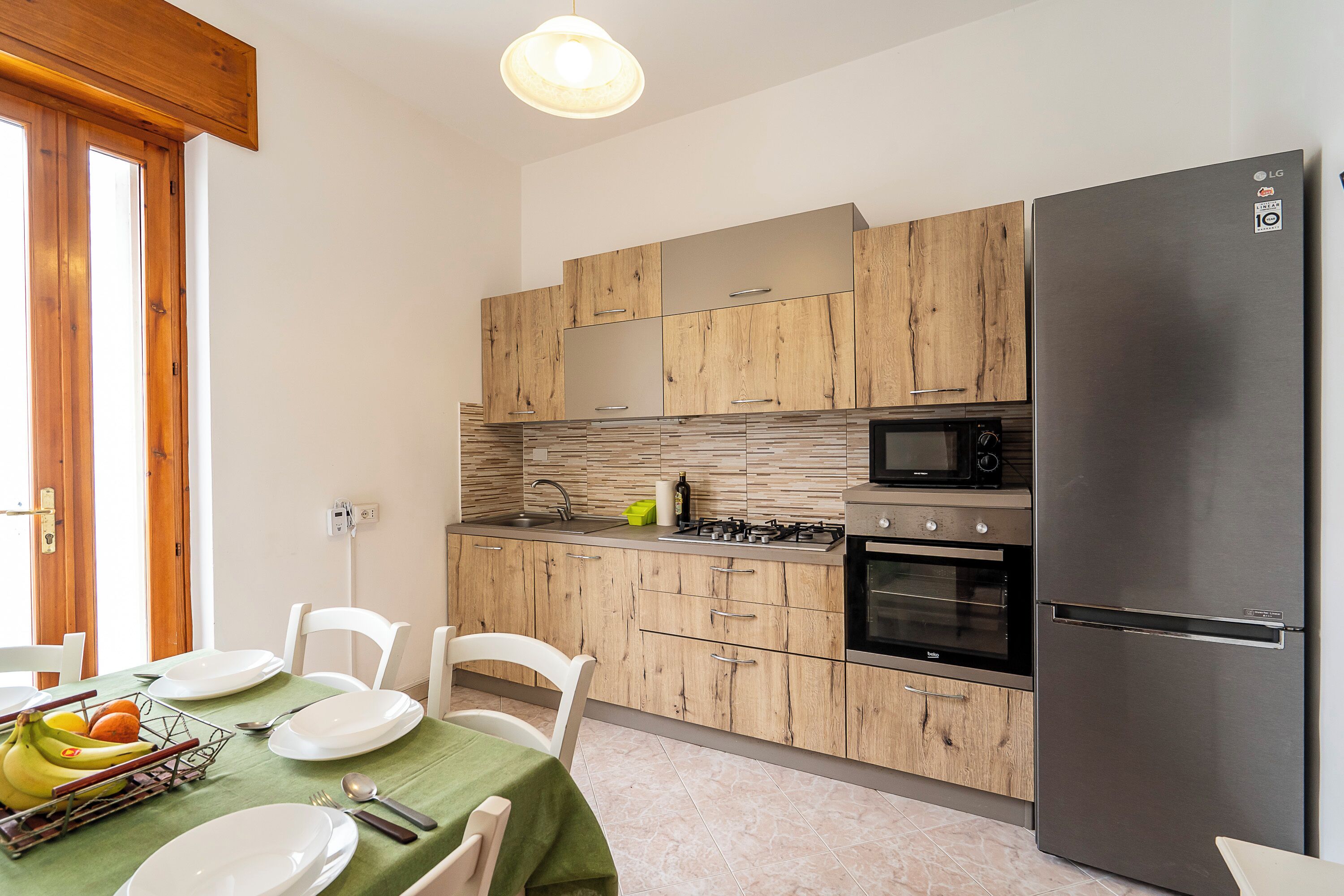 Um frigorífico, um forno, uma placa de cozinha, uma cafeteira/bule 