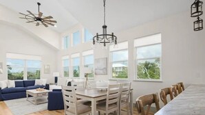 Uma sala de estar espaçosa com uma mesa de jantar, cadeiras e um sofá.