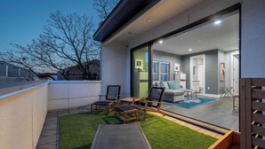 Um pátio moderno ao ar livre com área de estar, uma piscina pequena e vista para o interior do edifício.