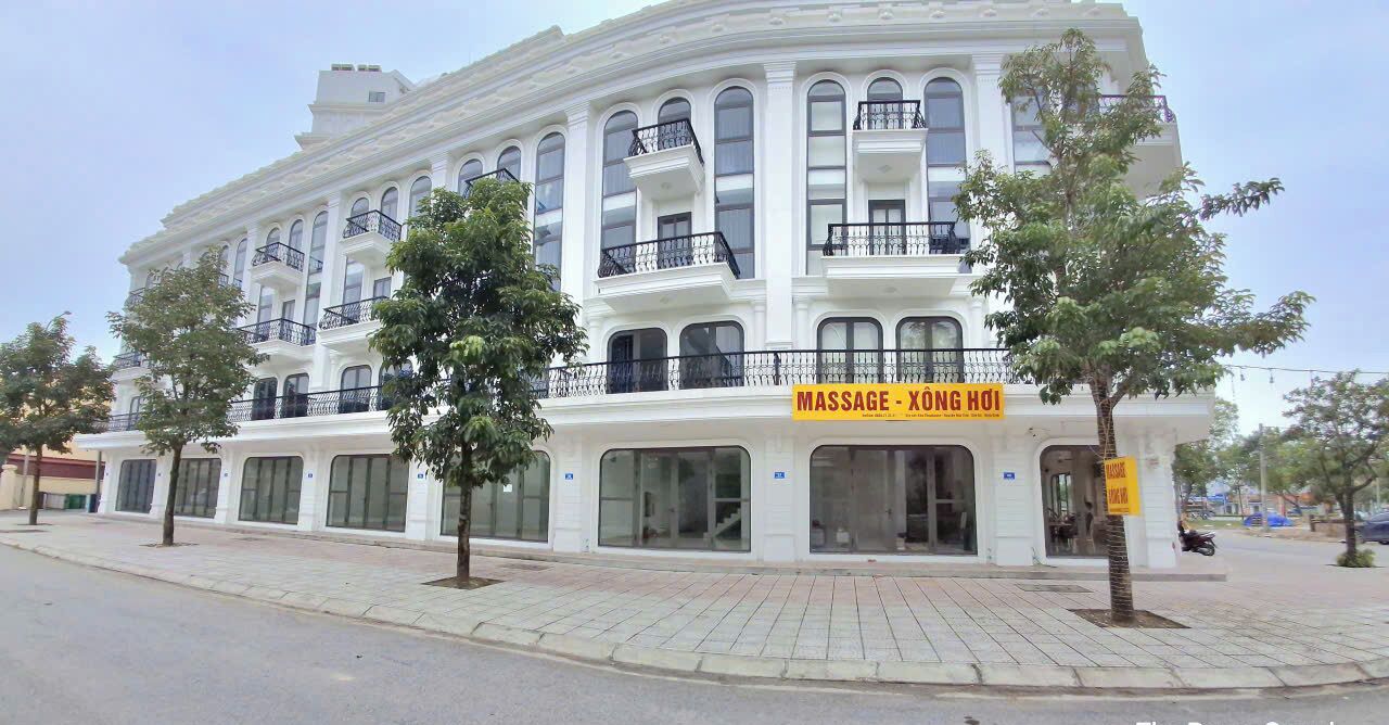 Um edifício branco com placa indicando serviço de massagem.