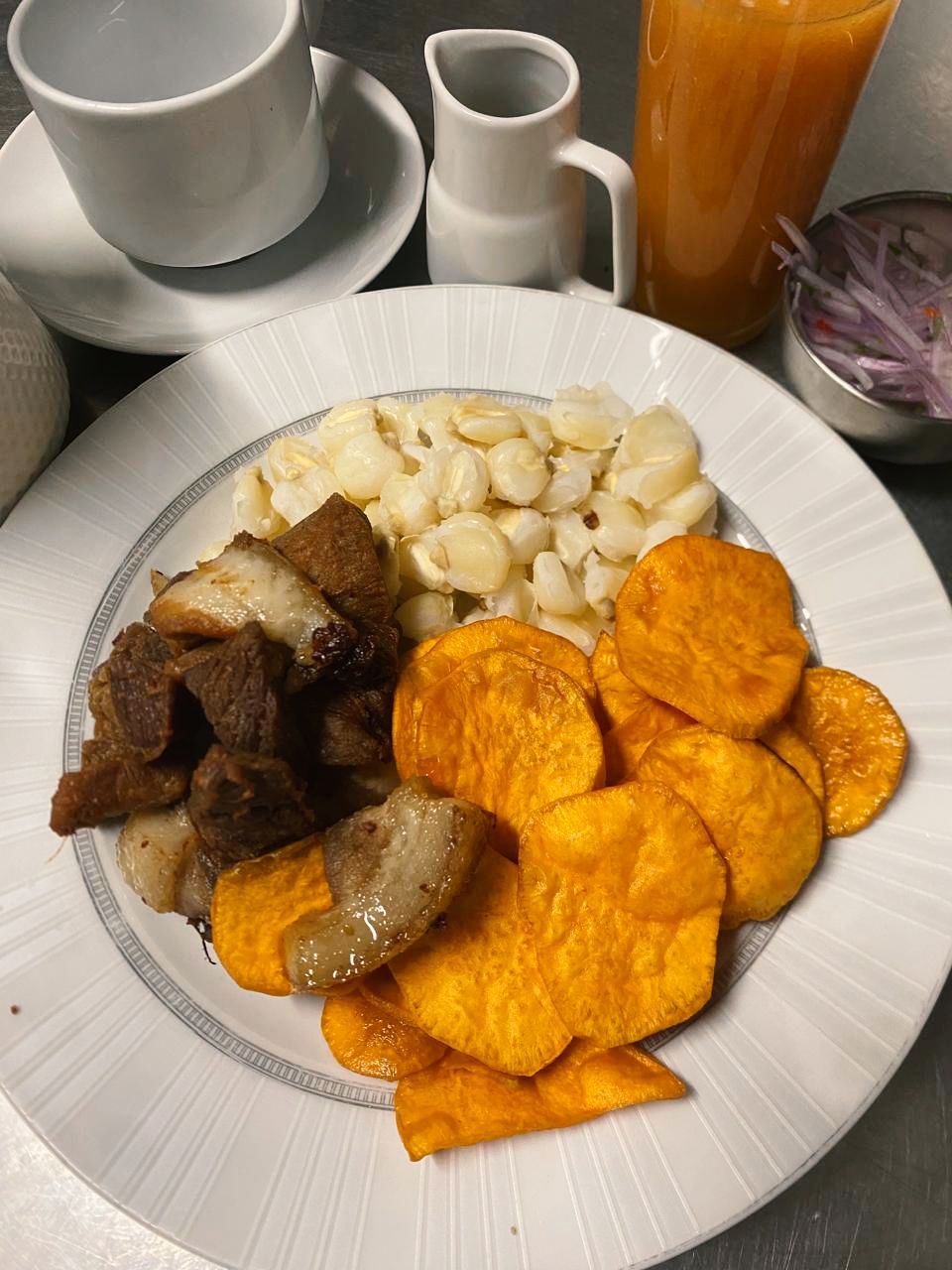 Um prato com comida, um jarro e um copo de suco de laranja.