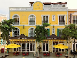 A yellow building with the signs "HÔI QUÃN" and "SOLÉA HOTEL" indicating a restaurant and hotel.