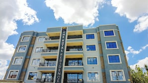 Hotel com vários andares, varandas e céu claro.