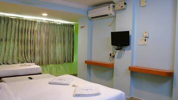 Quarto de hotel com duas camas, televisão, aparelho de ar condicionado e cortina verde.