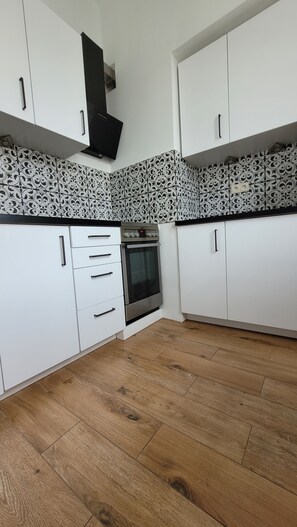 Apartamento Comfort | Cozinha privada | Um frigorífico/congelador grande, um micro-ondas, um forno 