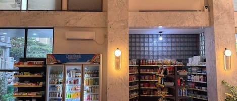 Uma farmácia com áreas refrigeradas e prateleiras repletas de diversos produtos.