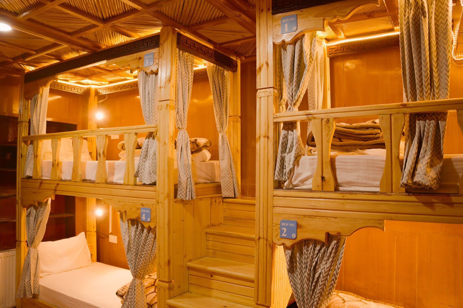 Quarto estilo cabana de madeira com beliches, cada um identificado com um número.