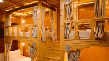 Quarto estilo cabana de madeira com beliches, cada um identificado com um número.