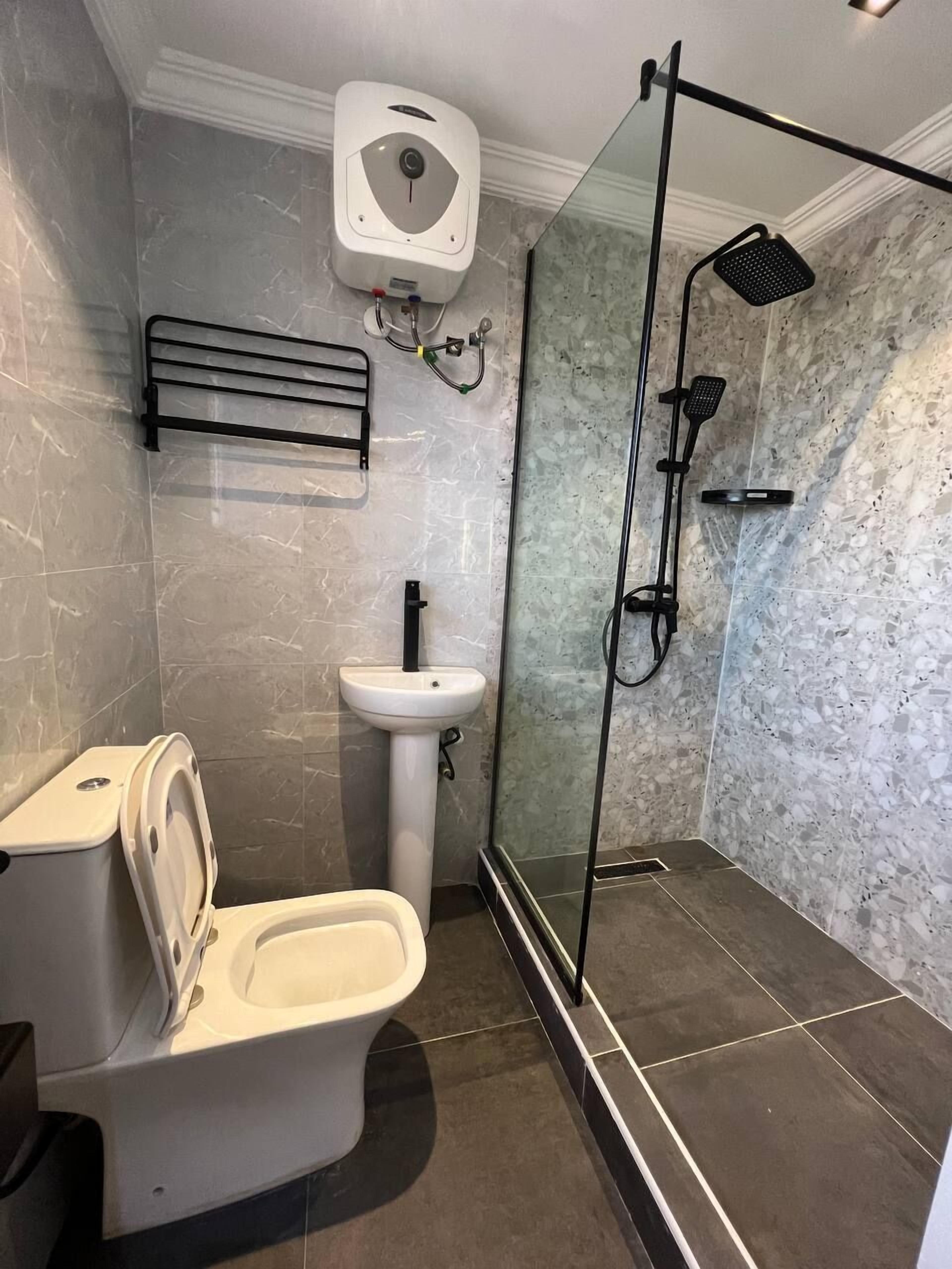 Uma casa de banho moderna com sanita, lavatório e cabine de duche em vidro.