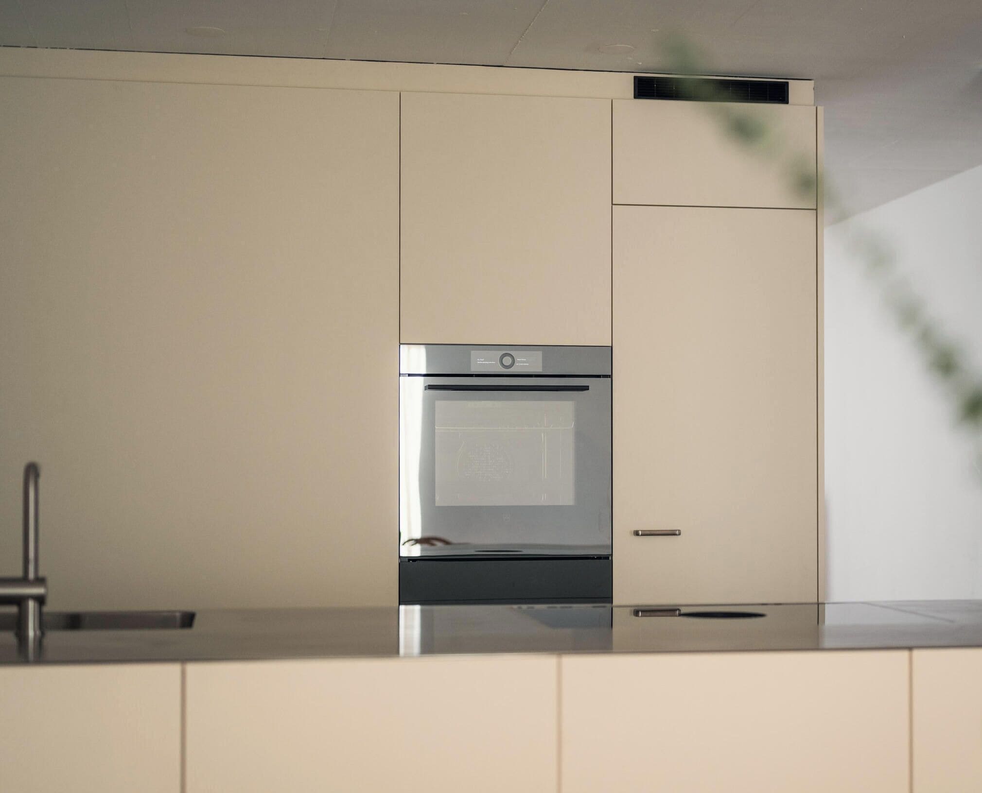 Uma cozinha moderna com forno embutido e exaustor de aço inoxidável.