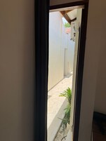 Um corredor estreito com uma porta que dá para uma área externa.