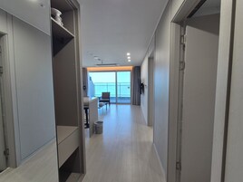 Corredor de hotel com vista para uma varanda, uma área de estar e uma lixeira.