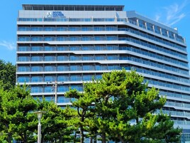 Um edifício de hotel com vários andares e design moderno, com um logotipo em destaque no topo.
