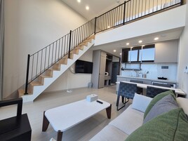 Um apartamento moderno com escada, área de refeições e cozinha.