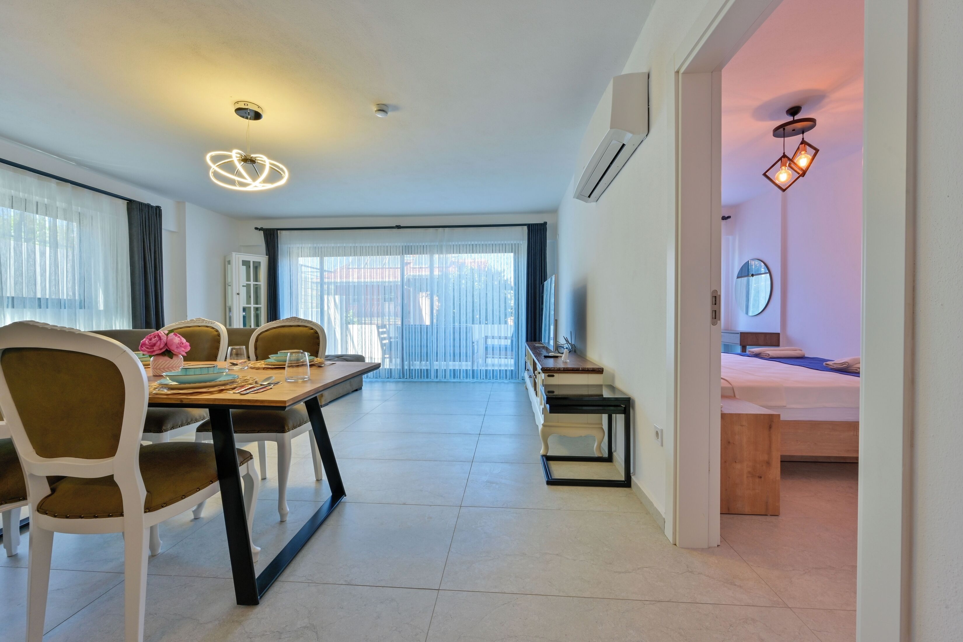 Quarto de hotel moderno com área de refeições, uma cama e um banheiro.