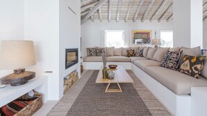Uma sala de estar moderna com um sofá, uma mesa de centro, um abajur e um ventilador de teto.